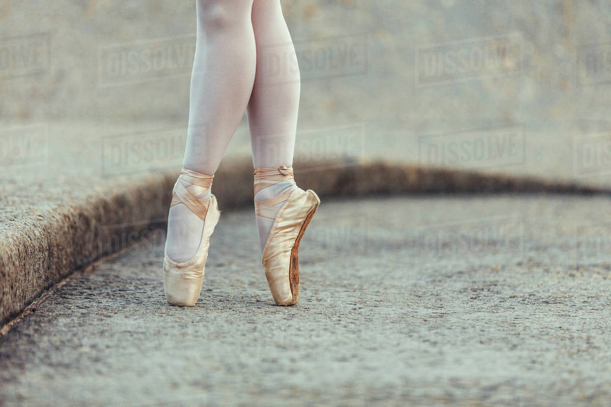 Closeup shot of legs of a female ballet dancer standing on her toes ...