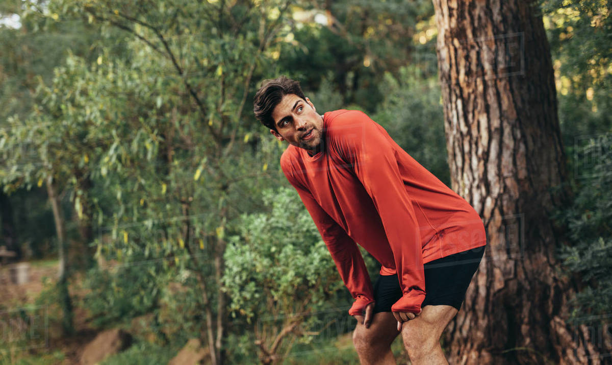 Man relaxing after intense workout. Athlete taking rest with hands ...