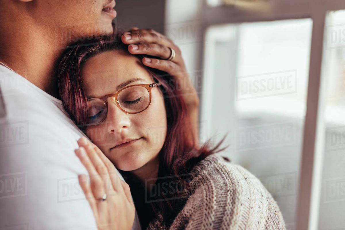 Close up of young couple in love embracing at home. Young woman leaning ...