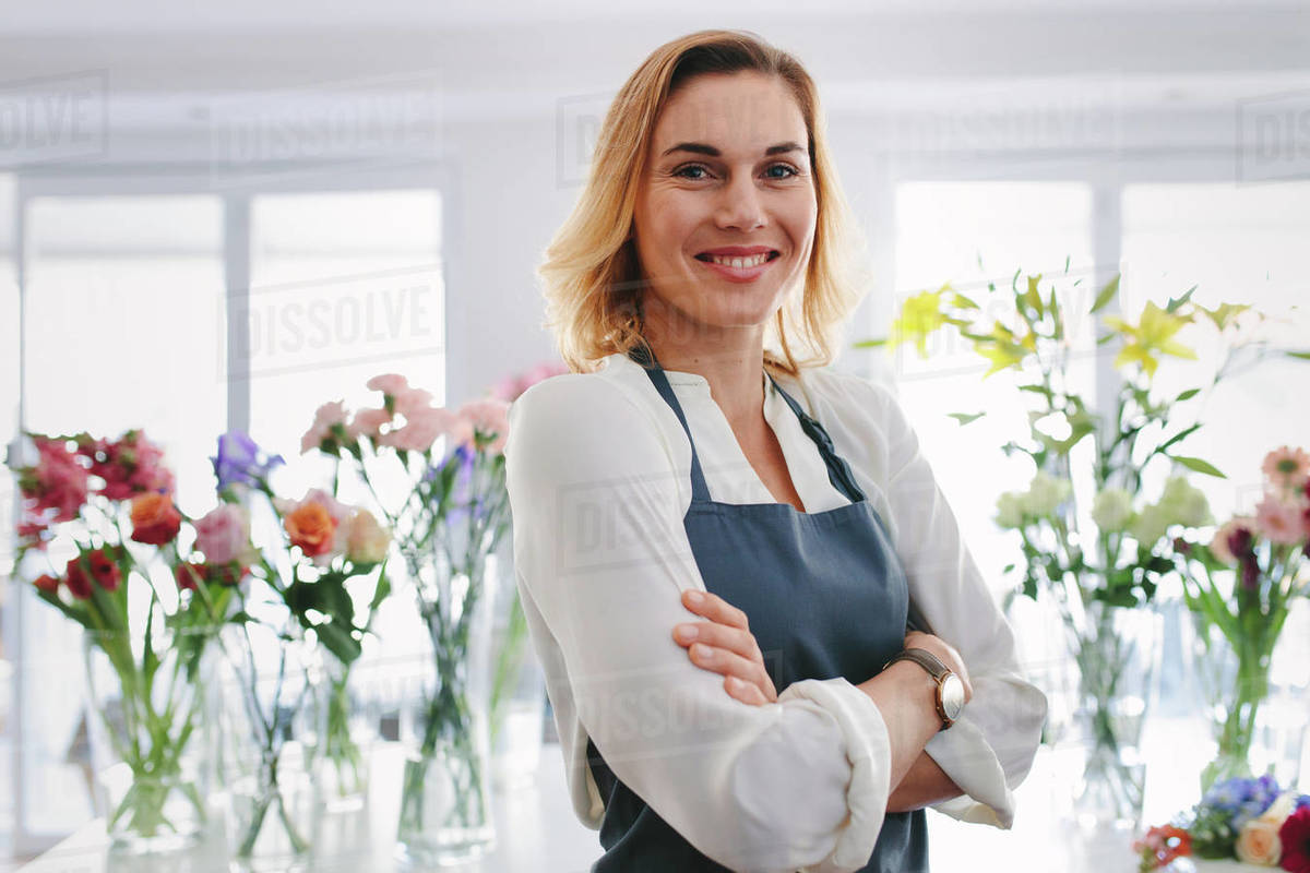 Portrait of a young successful florist owner standing in her own flower ...