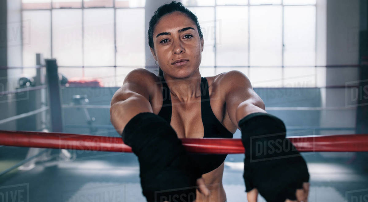 Female boxer having muscular body standing inside a boxing ring. Boxer ...