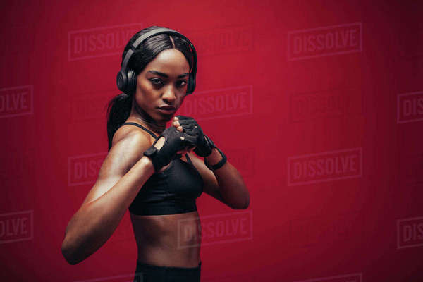 Tough black woman with headphones standing in fighting stance. African ...