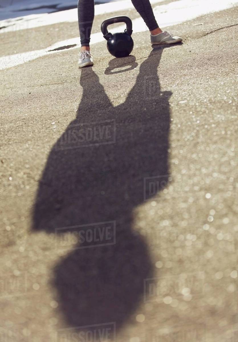 Shadow of a trainer with a kettlebell - Stock Photo - Dissolve