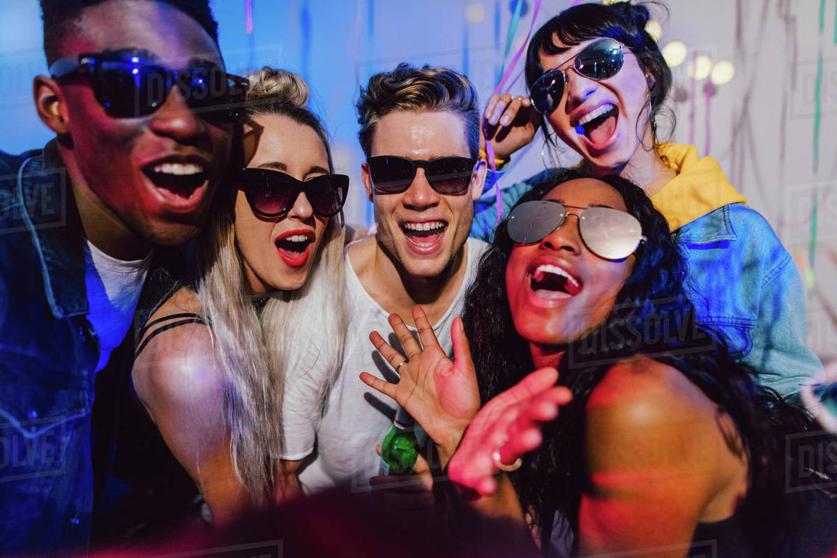 Friends posing for a selfie wearing dark sunglasses at a house party ...