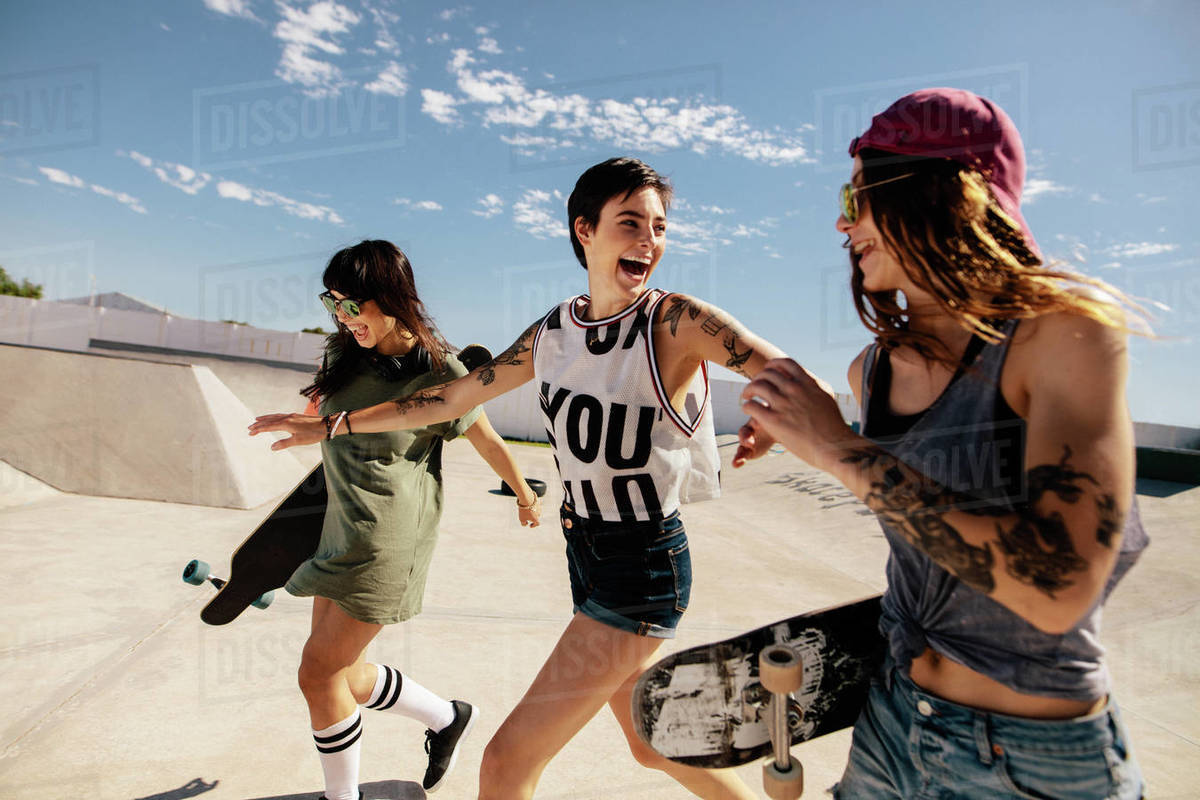 Group of female skaters running and having fun at skate park. Urban ...