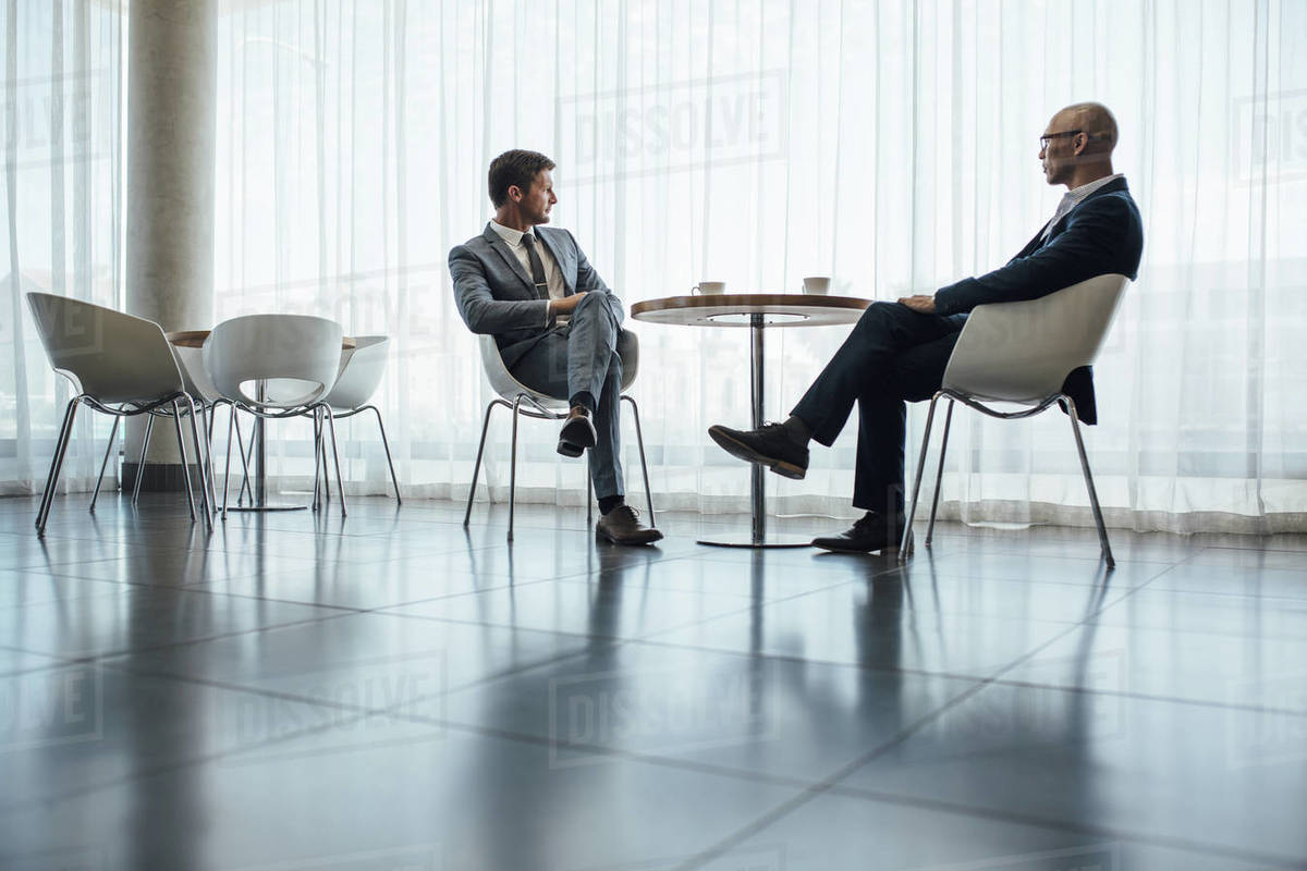 Two people meeting in office cafe. Business partners sitting at cafe ...