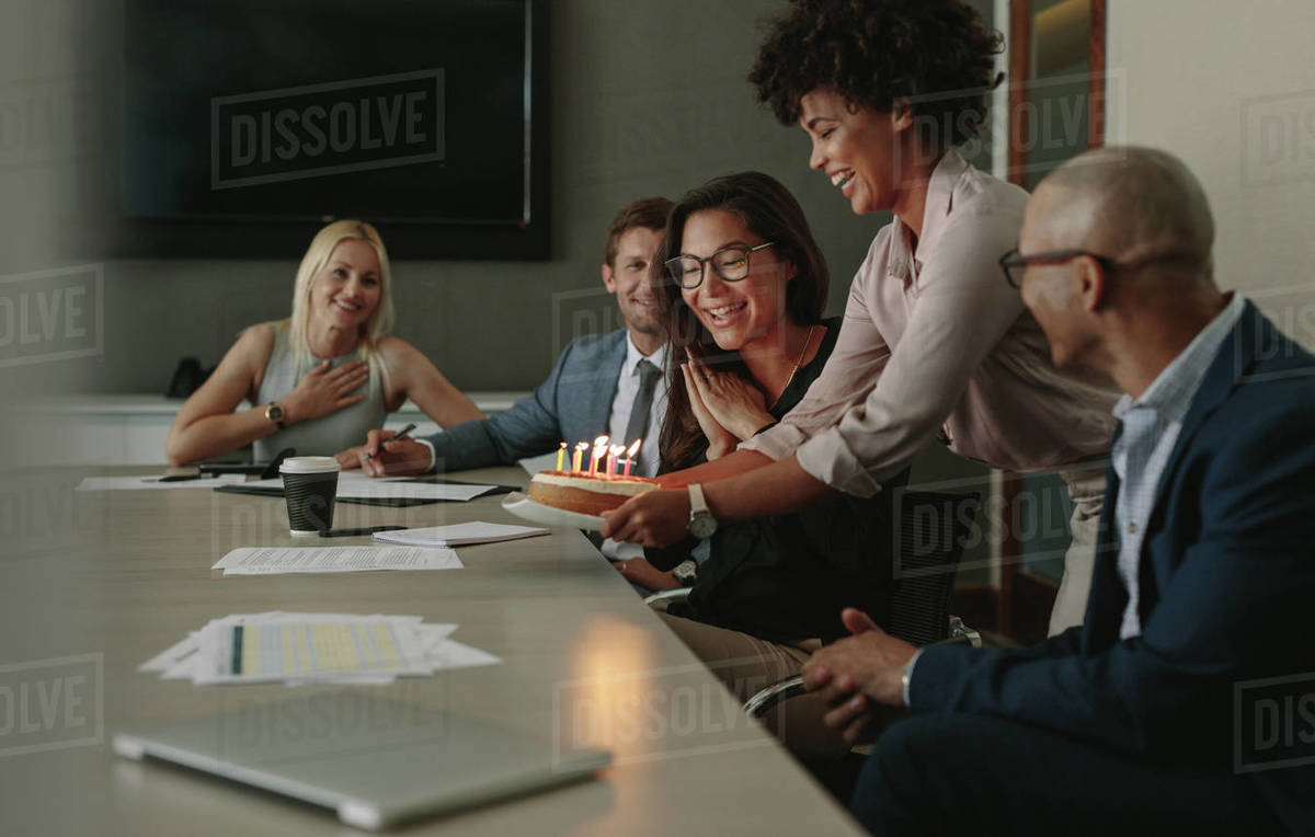 Group of business people celebrating a female executive's birthday in ...