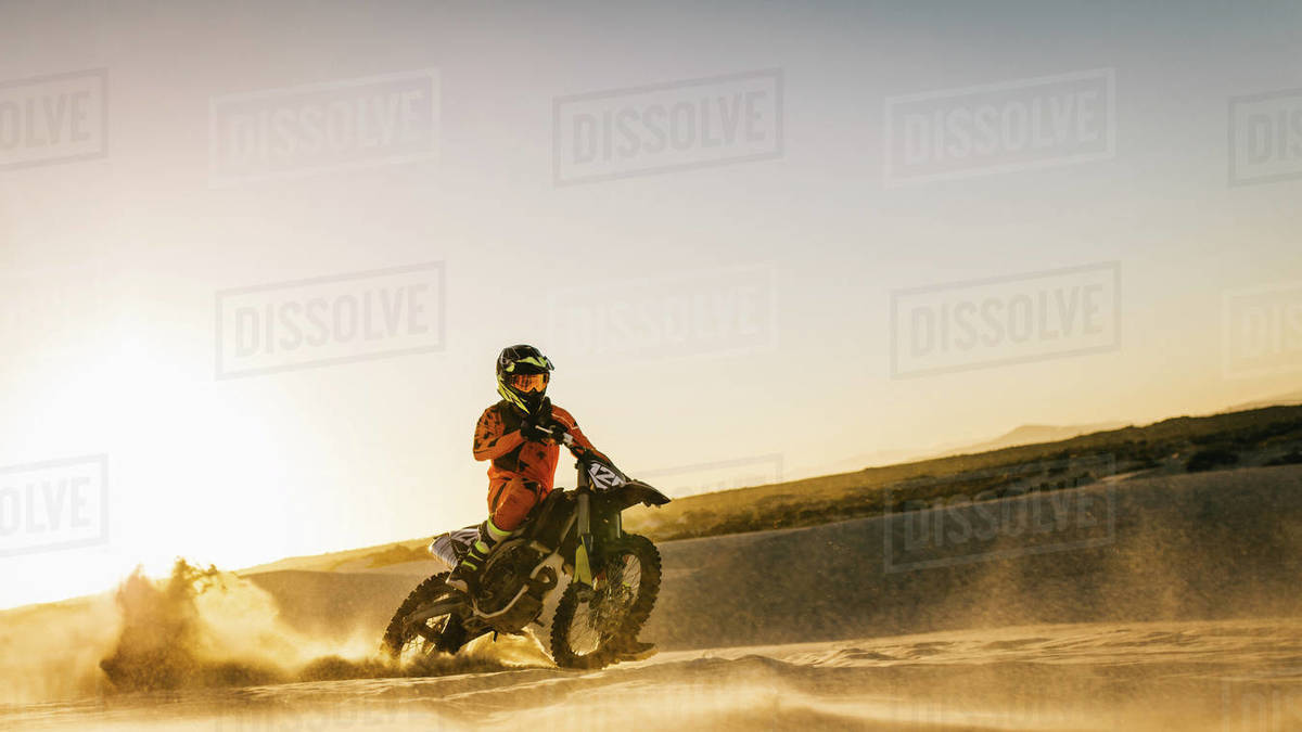 Rider riding dirt bike in the sand. Motocross race practice in desert ...