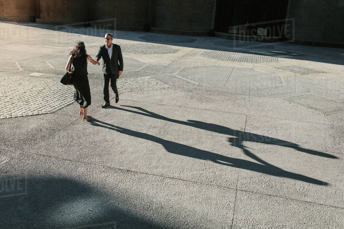 Businesswoman and a businessman walking forward to shake hands on a ...