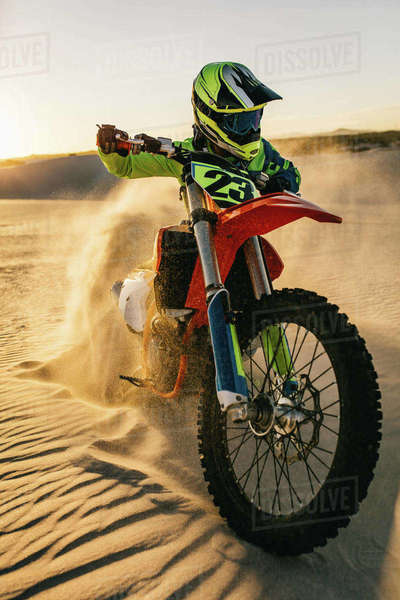 Motocross rider riding his bike on a sand dune. Motorcycle rider in ...