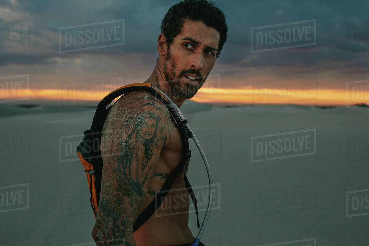 Fit young man in desert during sunset. Male athlete in desert with ...