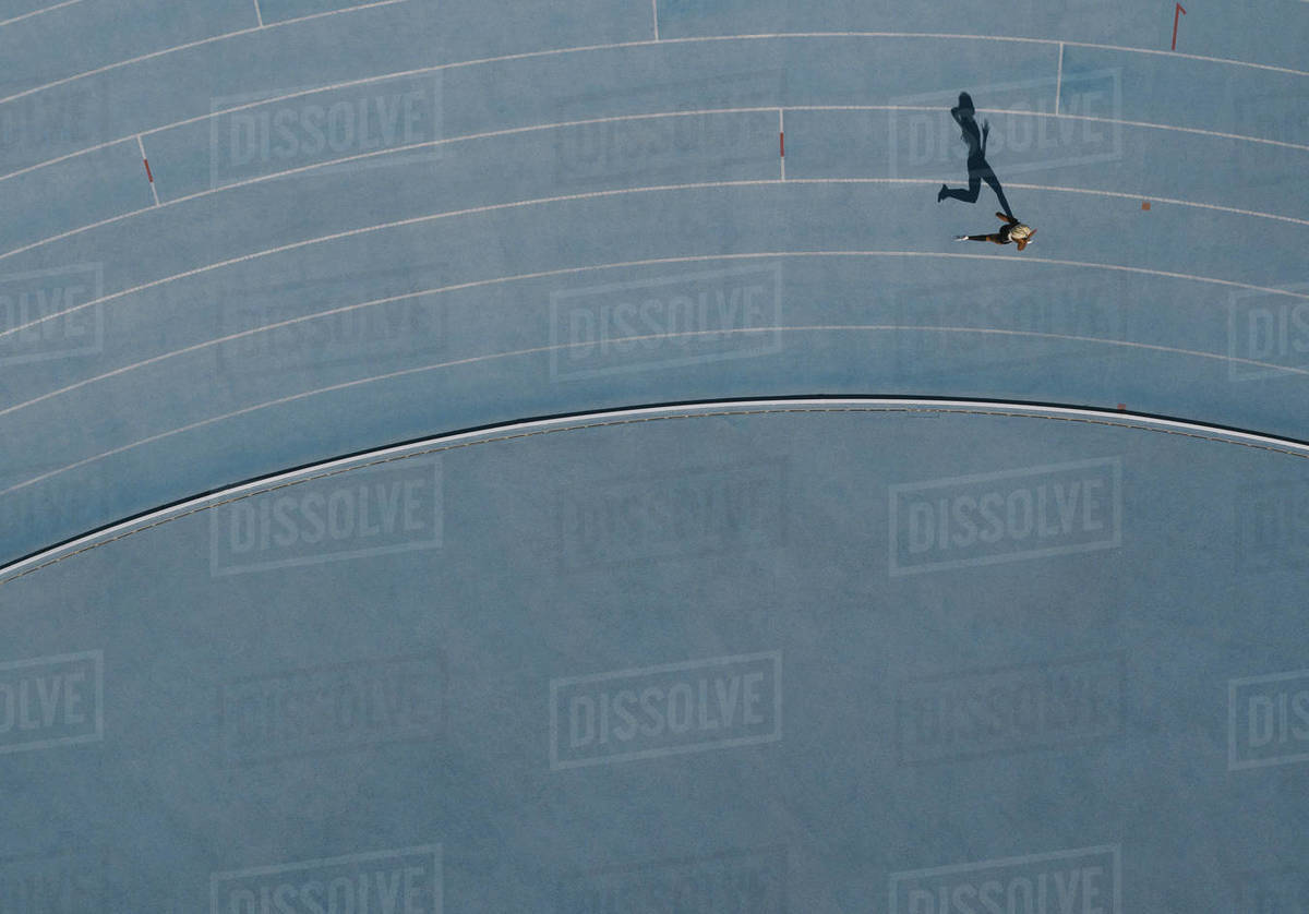 Sprinter running on athletic track. Top view of a sprinter running on ...
