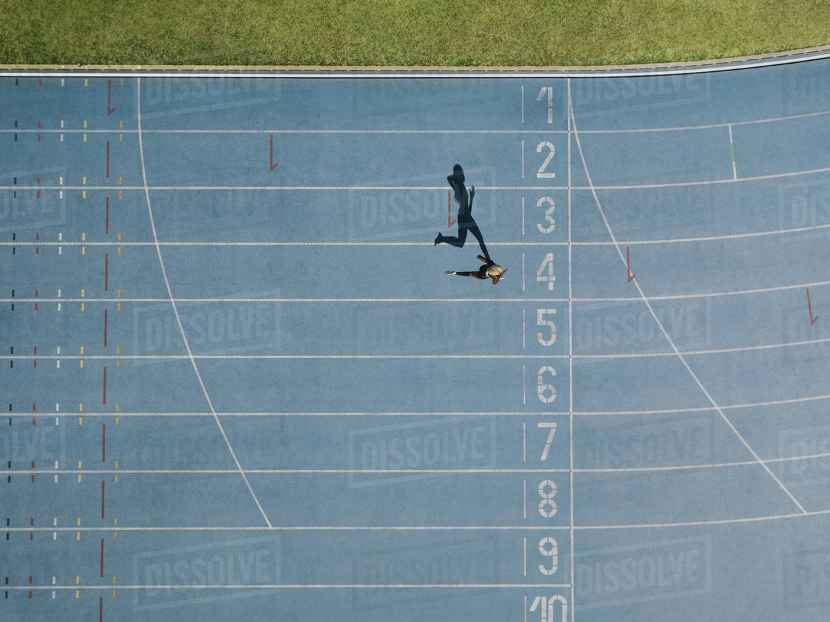 Female sprinter running on athletic track nearing the finish line. Top ...
