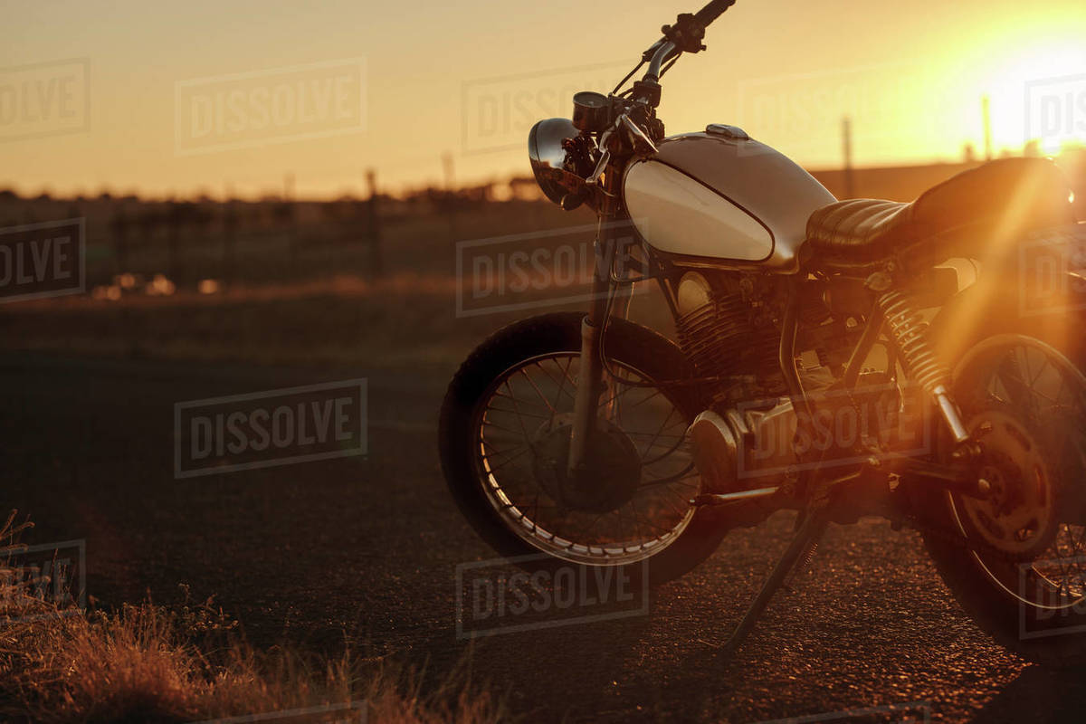 Classic motorbike standing on the road during sunset. Vintage ...