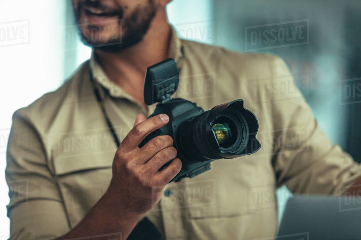 Portrait of a photographer holding a DSLR camera. Photographer holding ...