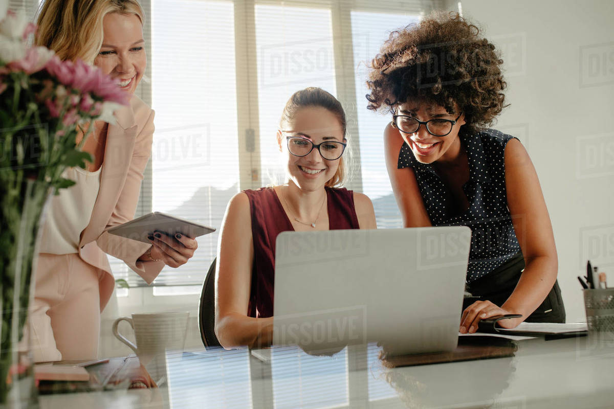 Three business women working together in the office and smiling. Female ...