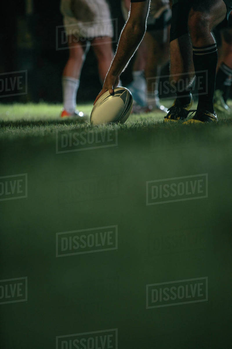 Low section of rugby player touching down the ball. Player picking up ...