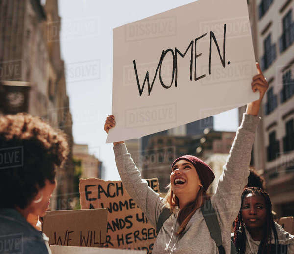 Happy young woman hand written protest sign at women's march. Group of ...