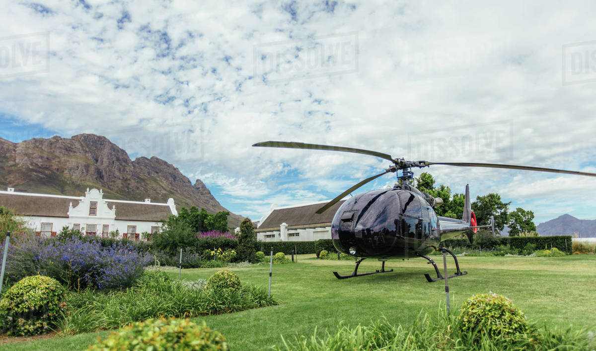 Private helicopter on the lawn of a villa. Helicopter in a beautiful ...
