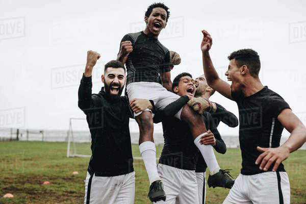 Footballers shouting in joy and pumping their fists after a win ...
