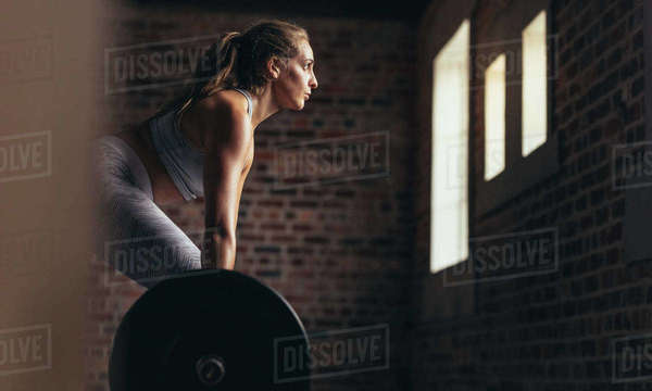 Determined fitness woman training with heavy weights in fitness club ...