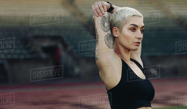 Side view portrait of a female runner doing stretching exercises ...