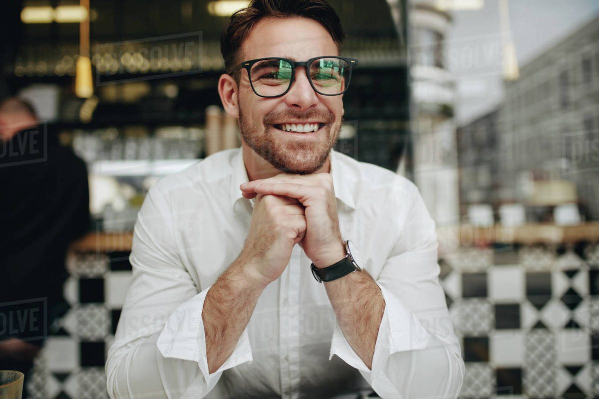 Man sitting in a cafe in relaxed mood and smiling. Smiling man sitting ...