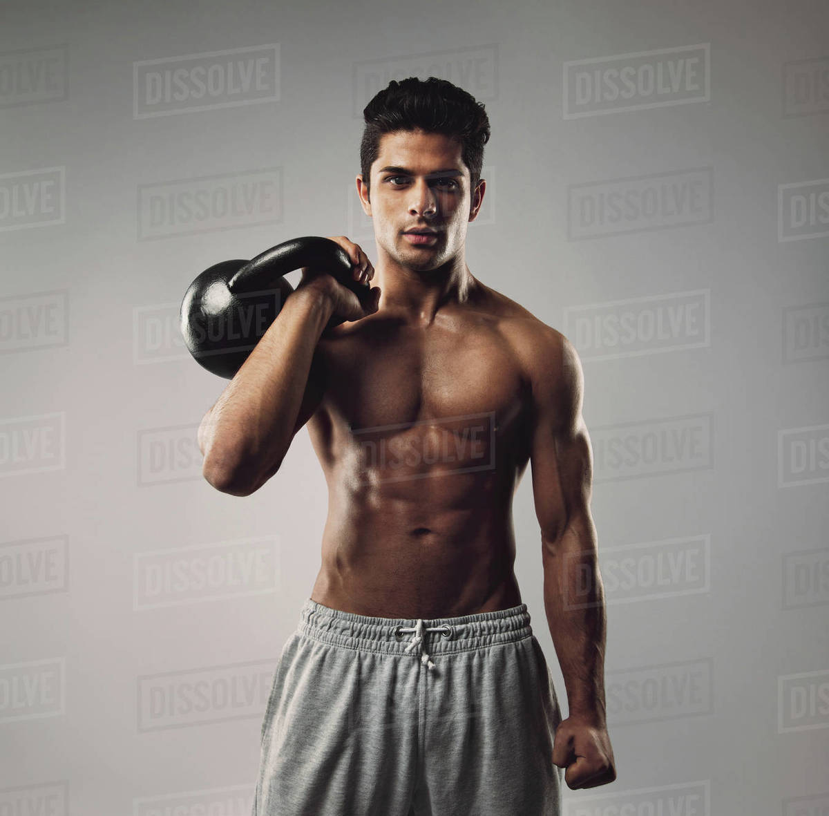 Portrait of strong young man working out with kettle bell. Young ...