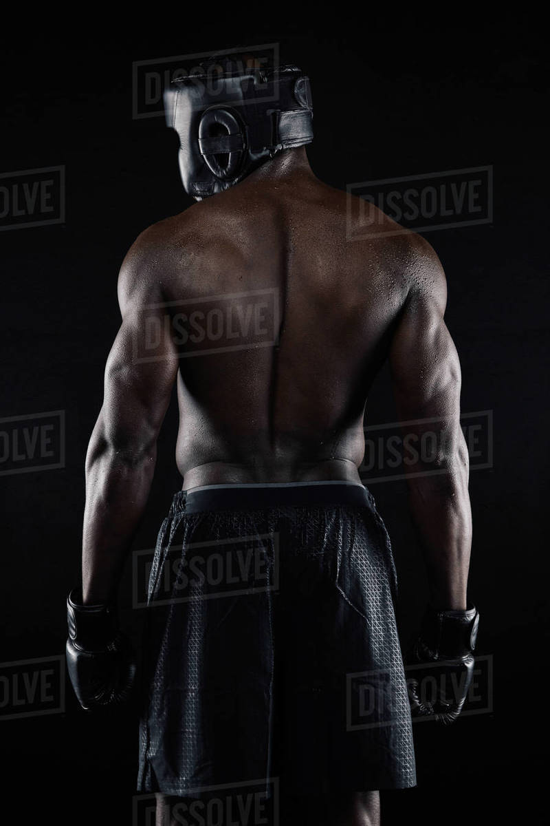 Back of strong young male boxer on black background. Young african male ...