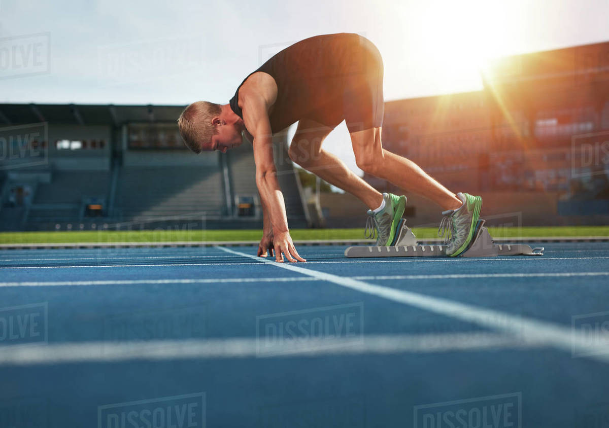Young man on starting position ready for running. Male athlete in the ...