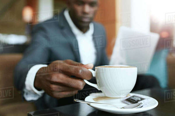 Close up shot of young man 's hand picking up cup of coffee ...