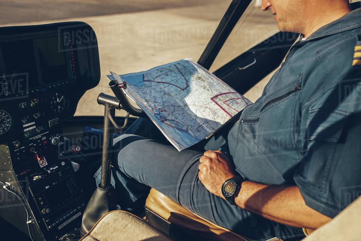 Close up shot of a helicopter pilot reading map while sitting in the ...