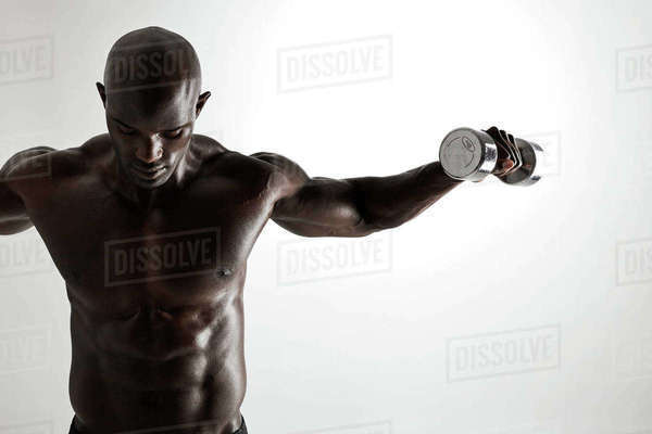 Shot of young african man doing dumbbell exercise for arms. Muscular ...