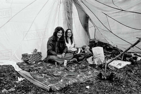 Three "hippies" camping under a parachute at music festival. - Stock ...