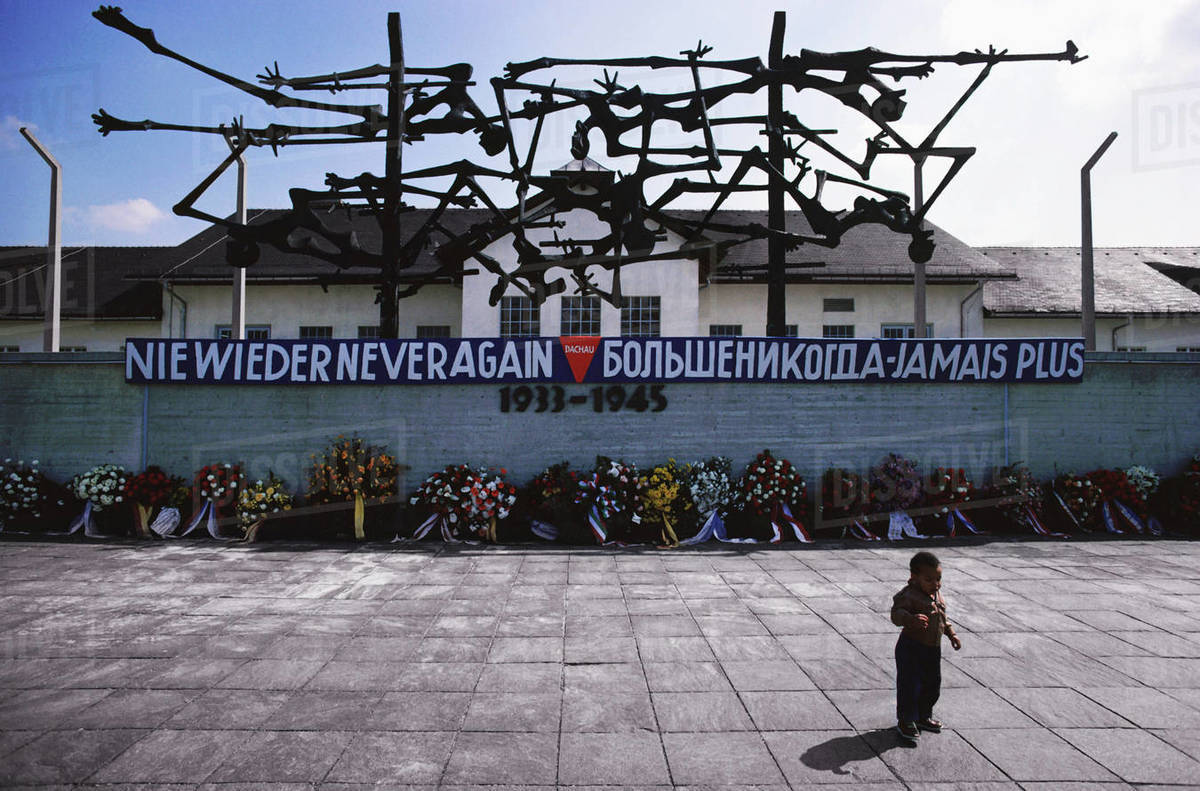 Child standing in front of a memorial, Dachau concentration camp ...