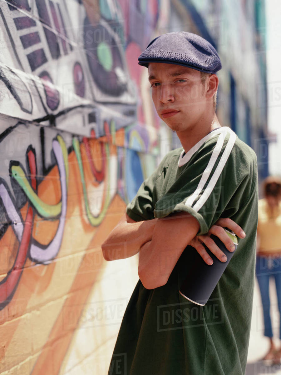 Teenage boy spray painting a wall - Royalty-free Stock Photo | Dissolve