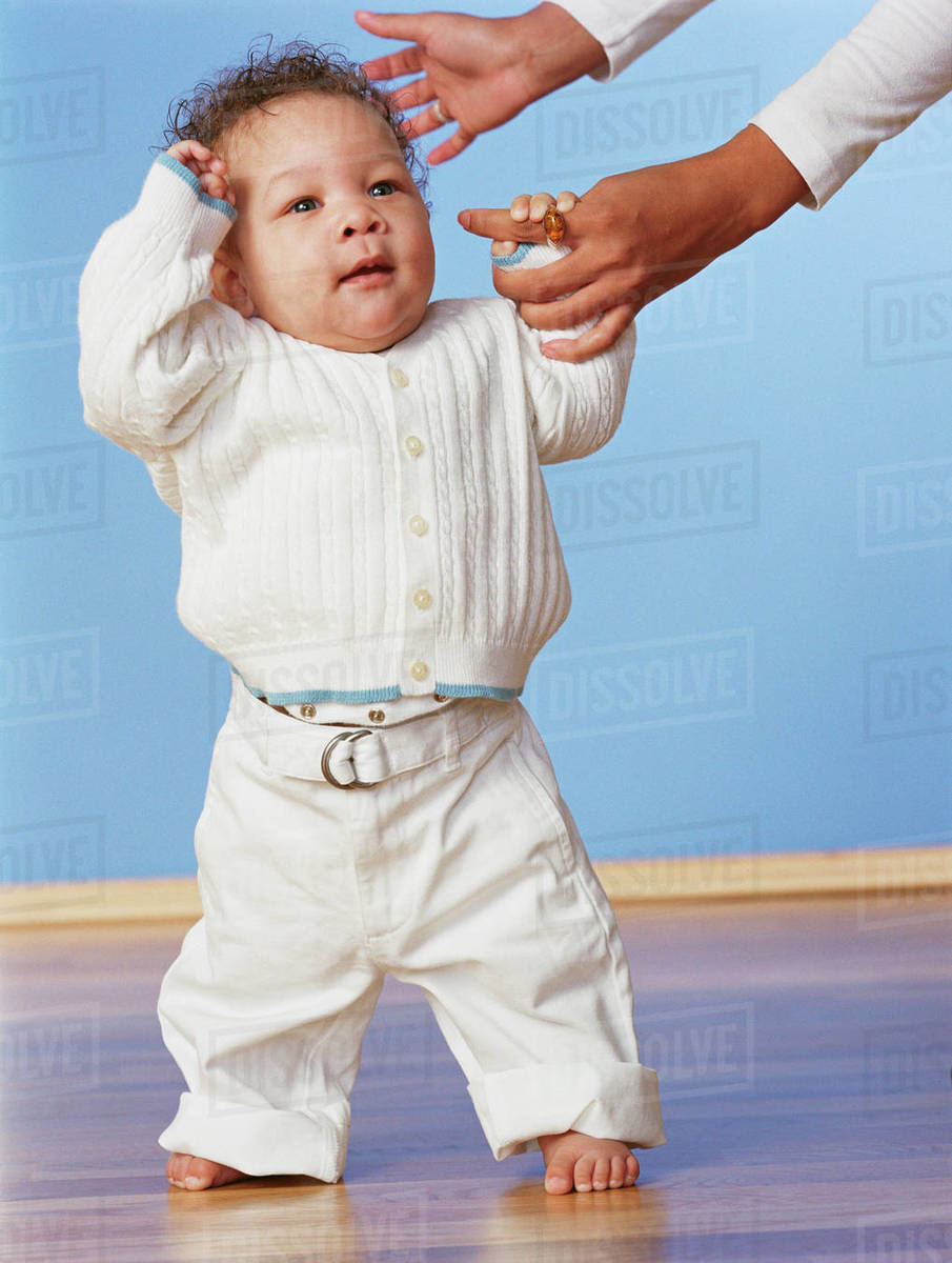 Baby boy taking first steps with mothers help - Royalty-free Stock ...