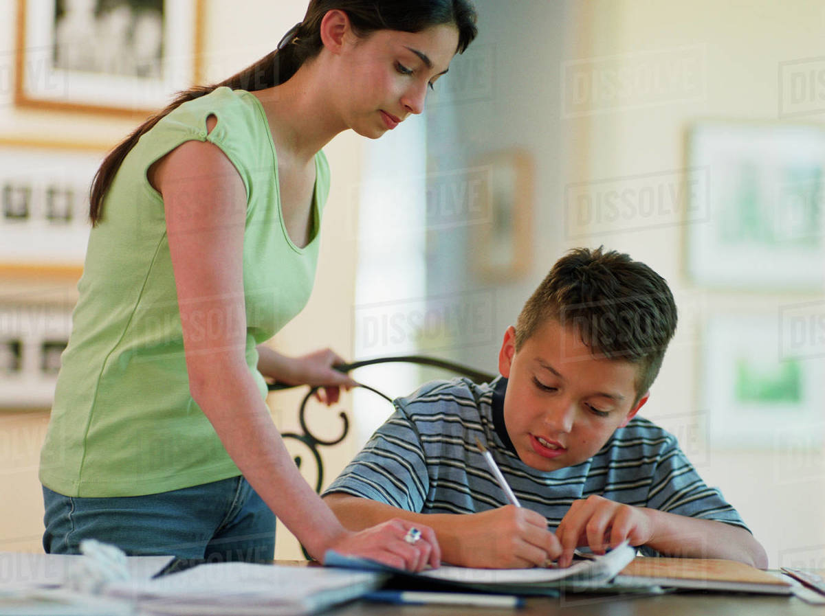 Sister helping brother with homework - Royalty-free Stock Photo | Dissolve