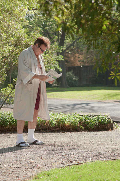 Man holding newspaper in driveway - Royalty-free Stock Photo | Dissolve