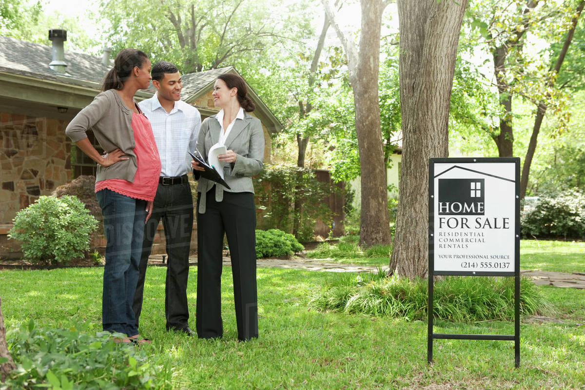 Couple and realtor looking at home for sale - Stock Photo - Dissolve
