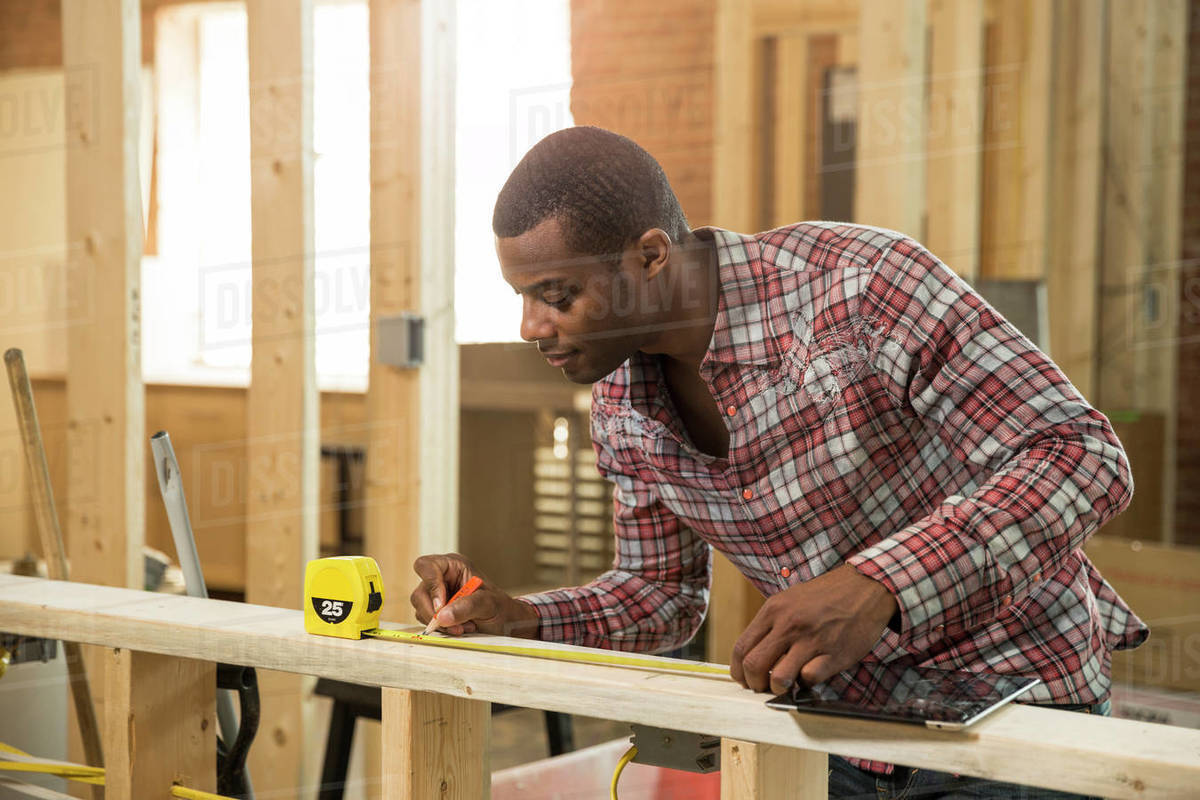 Worker measuring wood at construction site - Royalty-free Stock Photo ...