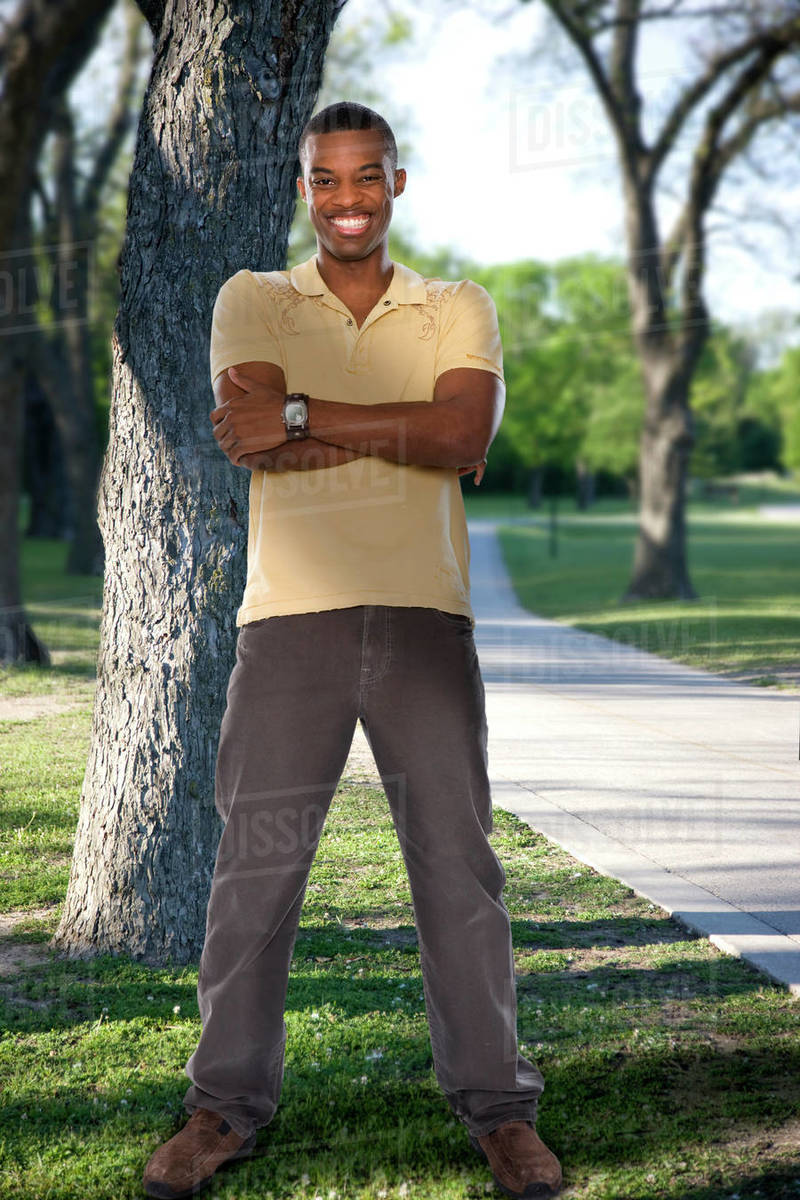Black man standing in park - Royalty-free Stock Photo | Dissolve