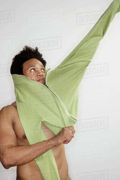 Black man pulling on sweater - Royalty-free Stock Photo | Dissolve