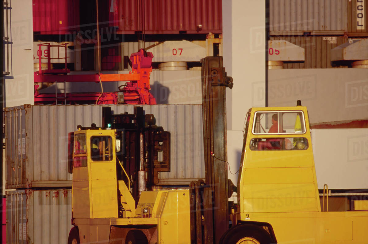 Two forklifts working with shipping containers at the port - Royalty ...