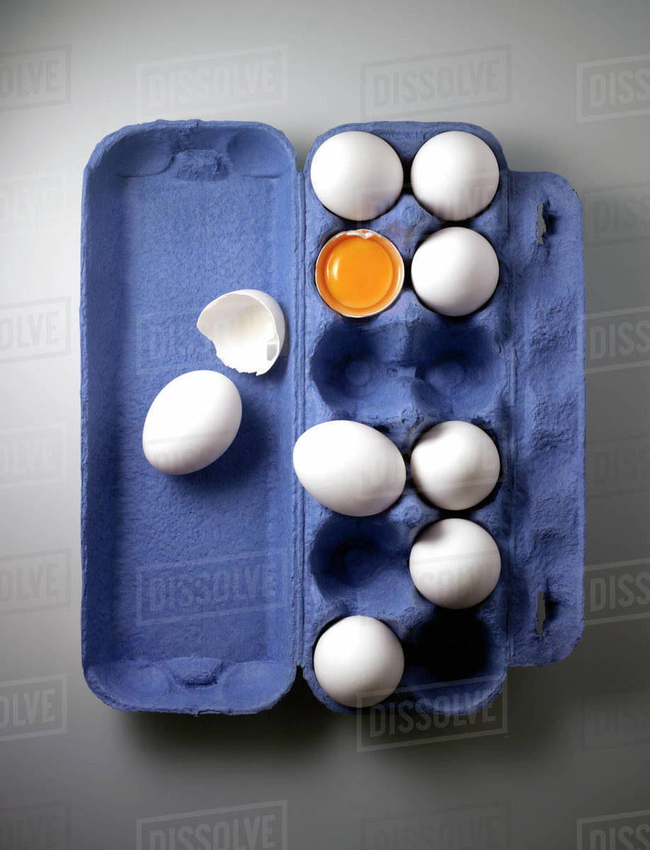 Aerial view of whole eggs and cracked egg showing yoke and broken shell ...