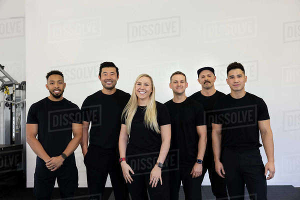 Group of personal trainers all wearing black looking into camera ...
