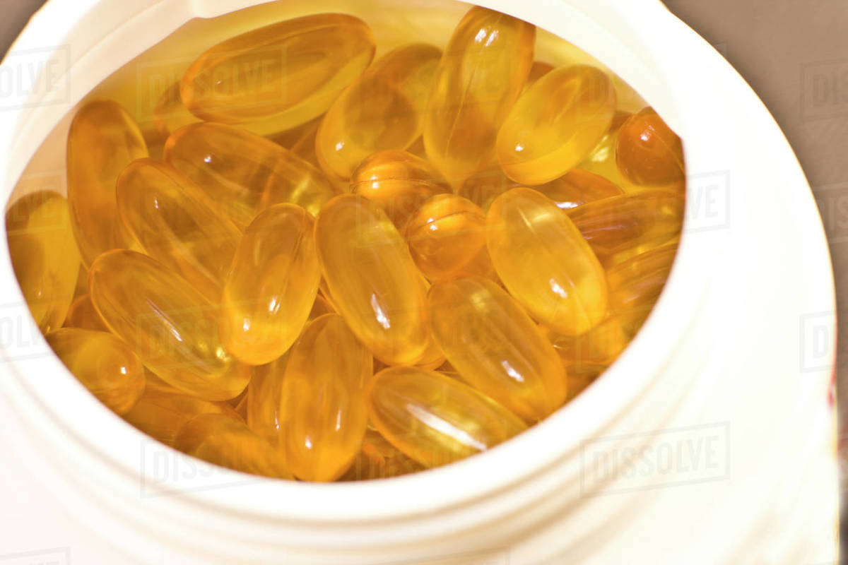 Vitamin capsules in white jar - Royalty-free Stock Photo | Dissolve