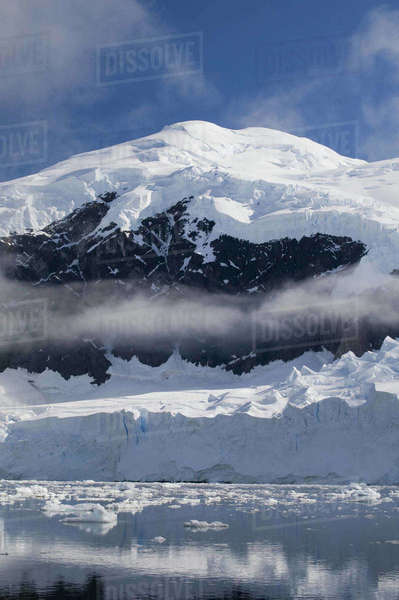 Ice floe floating on water in front of a mountain, Neko Harbor ...
