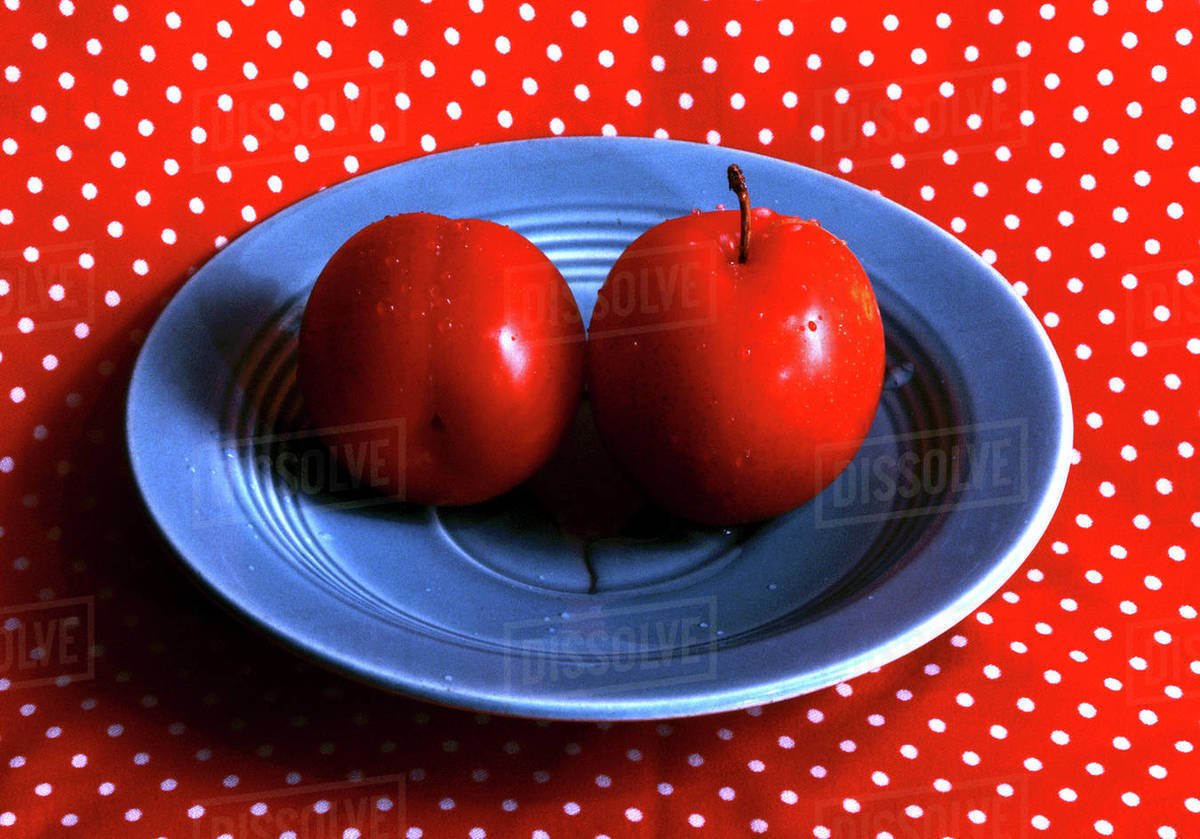 Close-up of two plums on a plate - Royalty-free Stock Photo | Dissolve