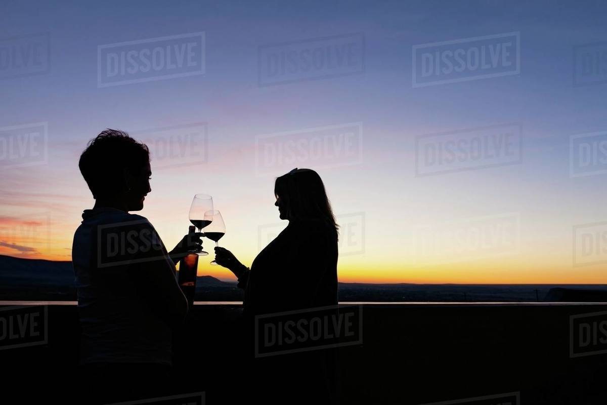 Two women toasting in silhouette at sunset. - Royalty-free Stock Photo ...